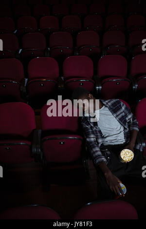 Man with popcorn sleeping in theatre Stock Photo - Alamy