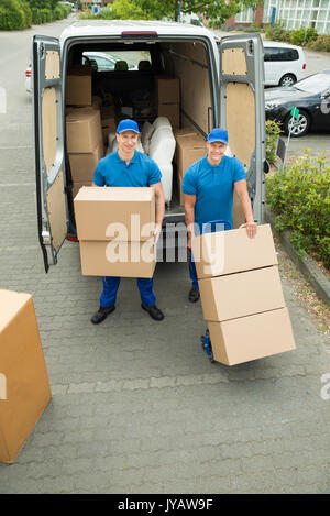 Delivery people loading boxes into van Stock Photo: 58219319 - Alamy