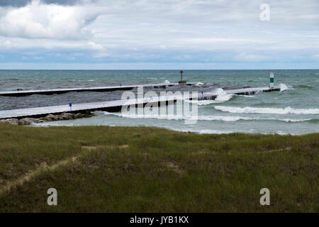 Waves crashing into the piers of the White Lake Channel and the beach ...