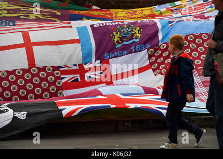 A fan walks past a large Burnley flag before the Premier League match ...