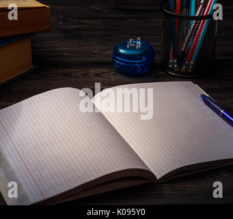 Busy student's desk with open notebook, school bag, text books and ...