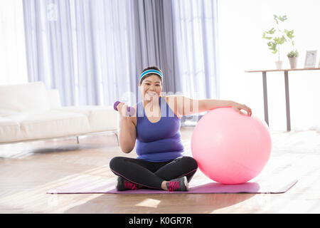 Young smiling fat woman sitting down during exercise Stock Photo - Alamy