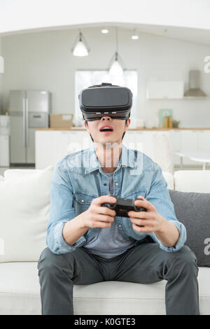 Male on a sofa enjoying a virtual reality experience Stock Photo - Alamy