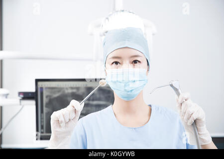 Portrait of dentist in operating dress pointing at an x-ray picture of ...