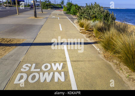 Worded marking SLOW painted to warning signs to slow down on a curving ...