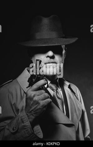 Detective holding a gun, he is wearing a fedora hat and a trench coat ...