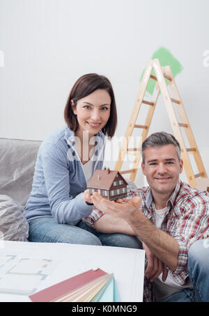 Couple building their dream house: they are holding a model house ...