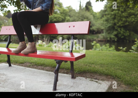 Low section of woman sitting on pier by sea Stock Photo - Alamy