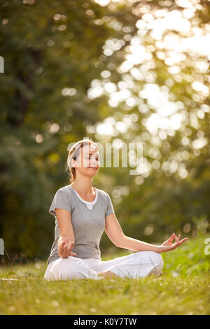 Young woman meditates or practicing yoga in the living room Stock Photo ...