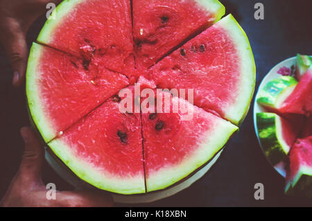 Cutting board of tasty watermelon, knife and napkin on dark background ...