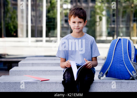 Child flipping through book pages outdoors in the city Stock Photo - Alamy