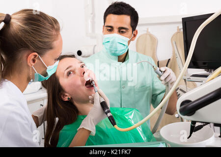 Sad american patient checking out her teeth at dentist Stock Photo - Alamy