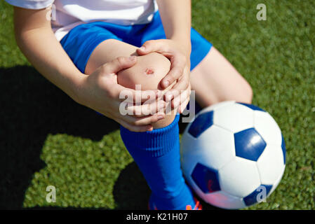 Injury of the knee in the boy football soccer player Stock Photo - Alamy