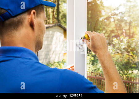 Worker with screwdriver installing window handle indoors Stock Photo ...