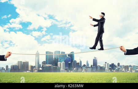Business concept of risk support and assistance with man balancing on ...