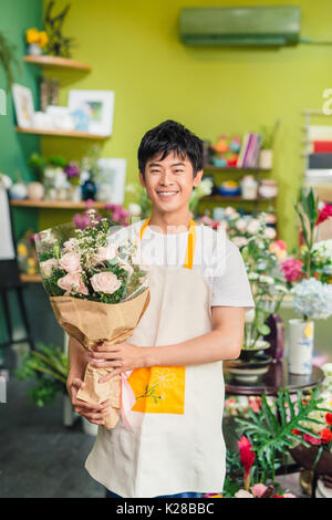 Handsome hispanic man working as shop assistance using smartphone at ...