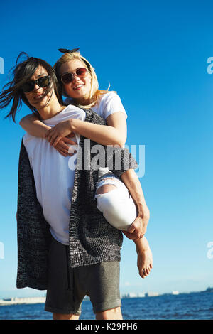 young pretty asian man posing in fashion style on light brown background, lifestyle people ...