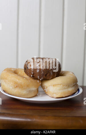 A single blueberry donut on two sweet, glazed donuts Stock Photo - Alamy
