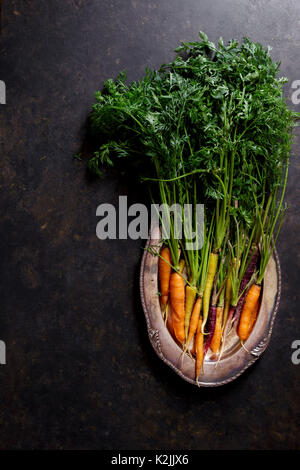 A vertical shot of a sliced orange on a wooden board on white fabric ...