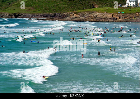 Surfer catching a wave at Polzeath in North Cornwall Stock Photo - Alamy
