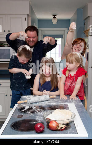 Flour fight in kitchen. Father and his son preparing a cake in the ...