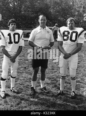 Johns Hopkins football coach Denny Cox standing with a whistle around ...