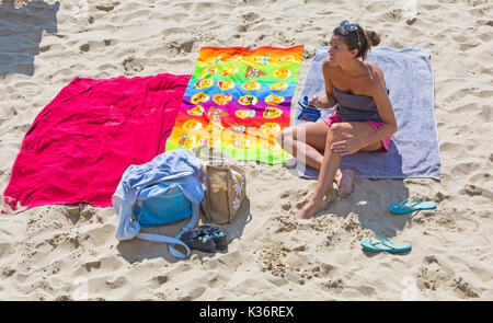 lovely woman with sunglasses holding an emoji icons smiling outdoors ...