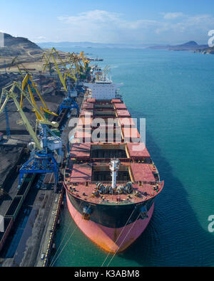 Dock crane loading coal / ore in inland vessel at Ghent seaport ...