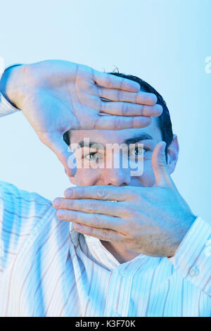 Man forms a rectangle with his hands and looks through Stock Photo - Alamy