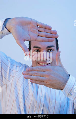 Man forms a rectangle with his hands and looks through Stock Photo - Alamy