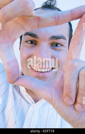 Man forms a rectangle with his hands and looks through Stock Photo - Alamy