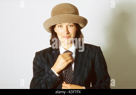 Woman at tie and care straightens tie node Stock Photo - Alamy