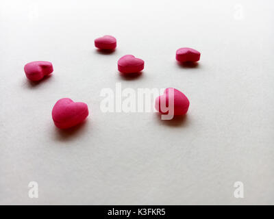 Heart-shaped tablets that form a heart shape on a yellow background ...