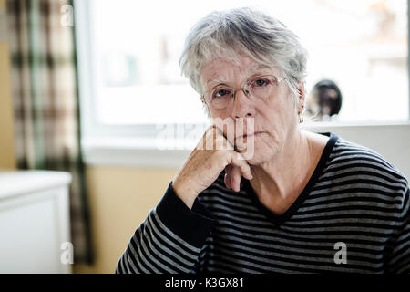 Granny is sitting near the window in the kitchen. Black and white ...