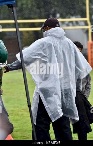 Football coach wearing poncho at rainy game Stock Photo - Alamy