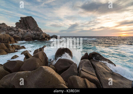 Sunset on modeled cliffs by wind framing blue sea Capo Testa Santa ...