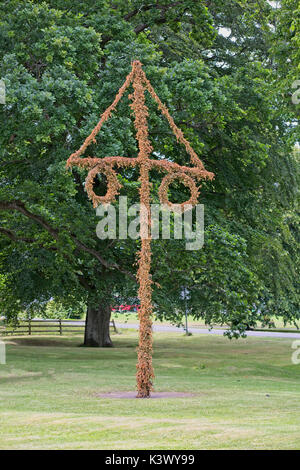 Traditional tall wooden maypole erected with ribbons and small flag- May pole and celebration ...