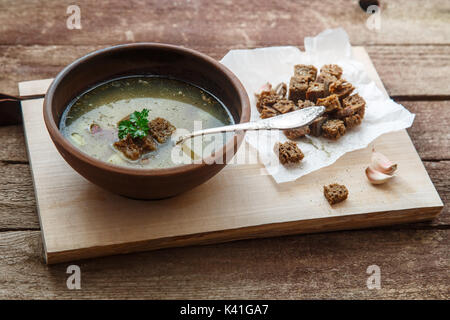 Homemade garlic soup with croutons close-up in a bowl on the table ...
