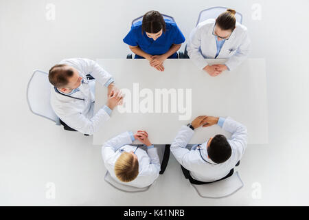 group of doctors sitting at empty table Stock Photo - Alamy