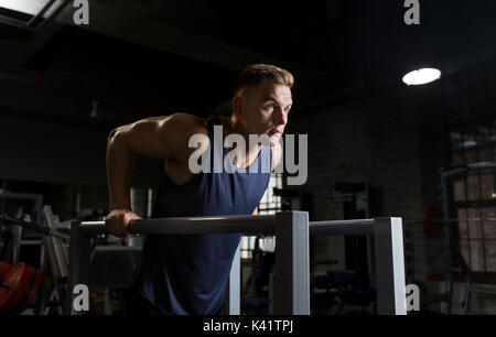 man doing triceps dip on parallel bars in gym Stock Photo - Alamy