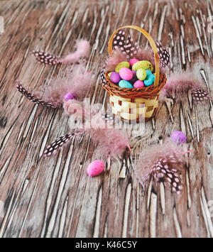 Easter colored eggs, feathers and spikes, on wooden background Stock ...