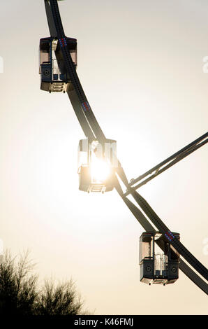 Big and high panoramic observation wheel in the evening in an urban ...