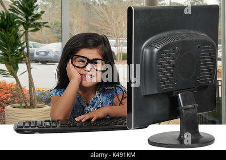 Computer savvy little girl using a desktop computer Stock Photo - Alamy