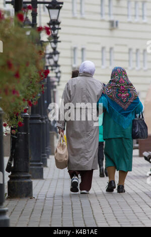 Two women in national Tatar clothes pours soup into plates for guests ...