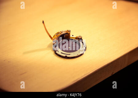 A man fixing photo camera lens on an office table Stock Photo - Alamy