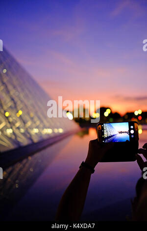 Louvre museum pyramid illuminated by sun rays at sunrise Stock Photo ...
