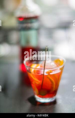Close-up of glass with alcoholic drink on background of flashing colors ...