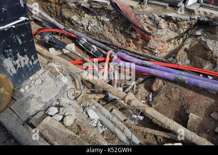 Pipe and cables in trench at road crossing laying pipelines. Building ...