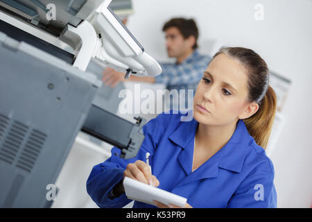 Young woman checking printer Stock Photo - Alamy