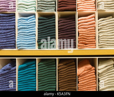 Rack with sweaters on white background Stock Photo - Alamy
